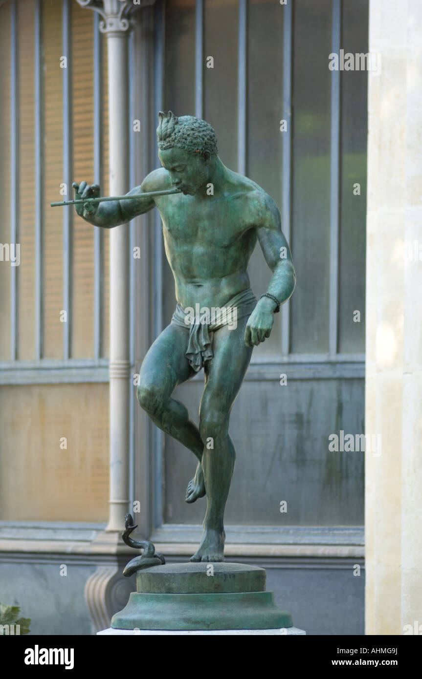 bronze statue representing African man playing a flute to charm a ...