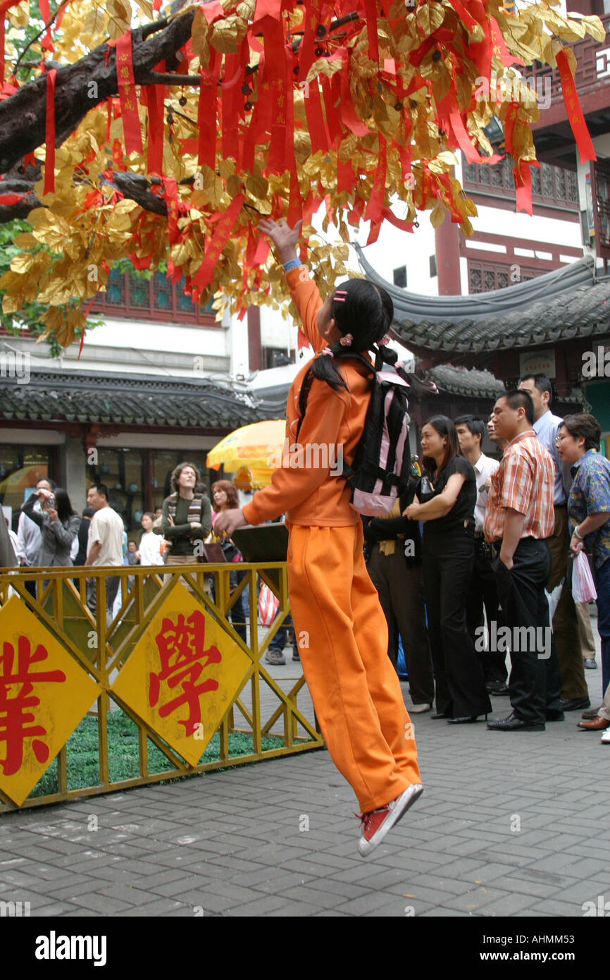 young girl jumping high and throwing her wish into the Lucky Tree Stock ...