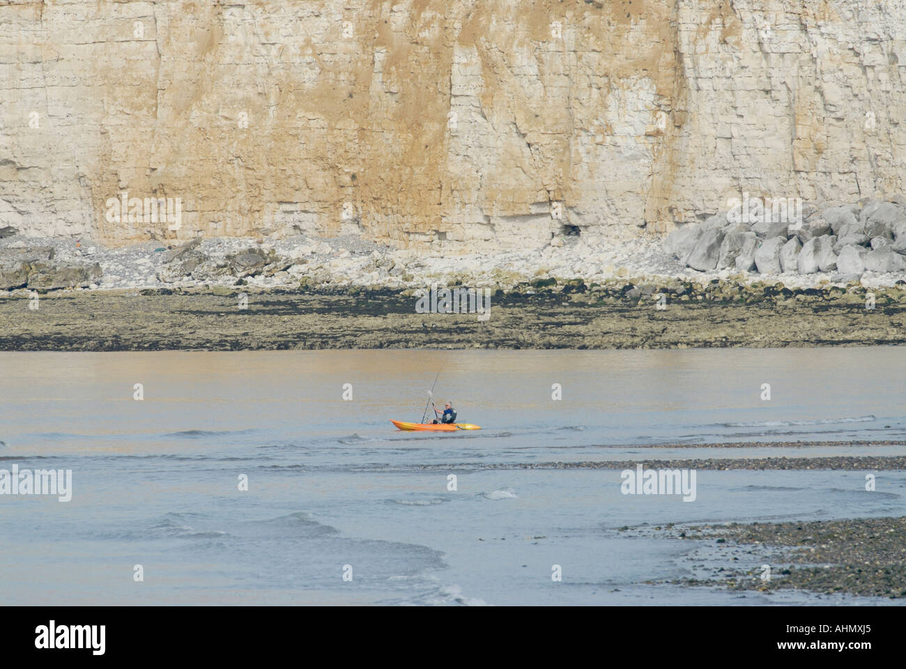 A canoeist sets off across Cuckmere haven with a fishing rod. Beach and ...