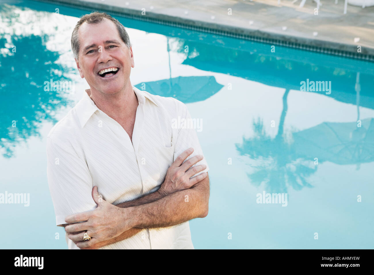 Man laughing by swimming pool Stock Photo - Alamy
