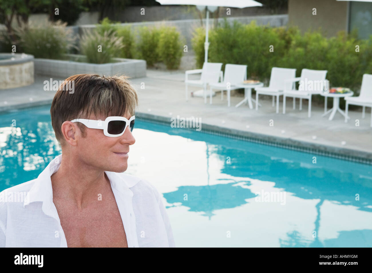 Man standing by swimming pool Stock Photo - Alamy