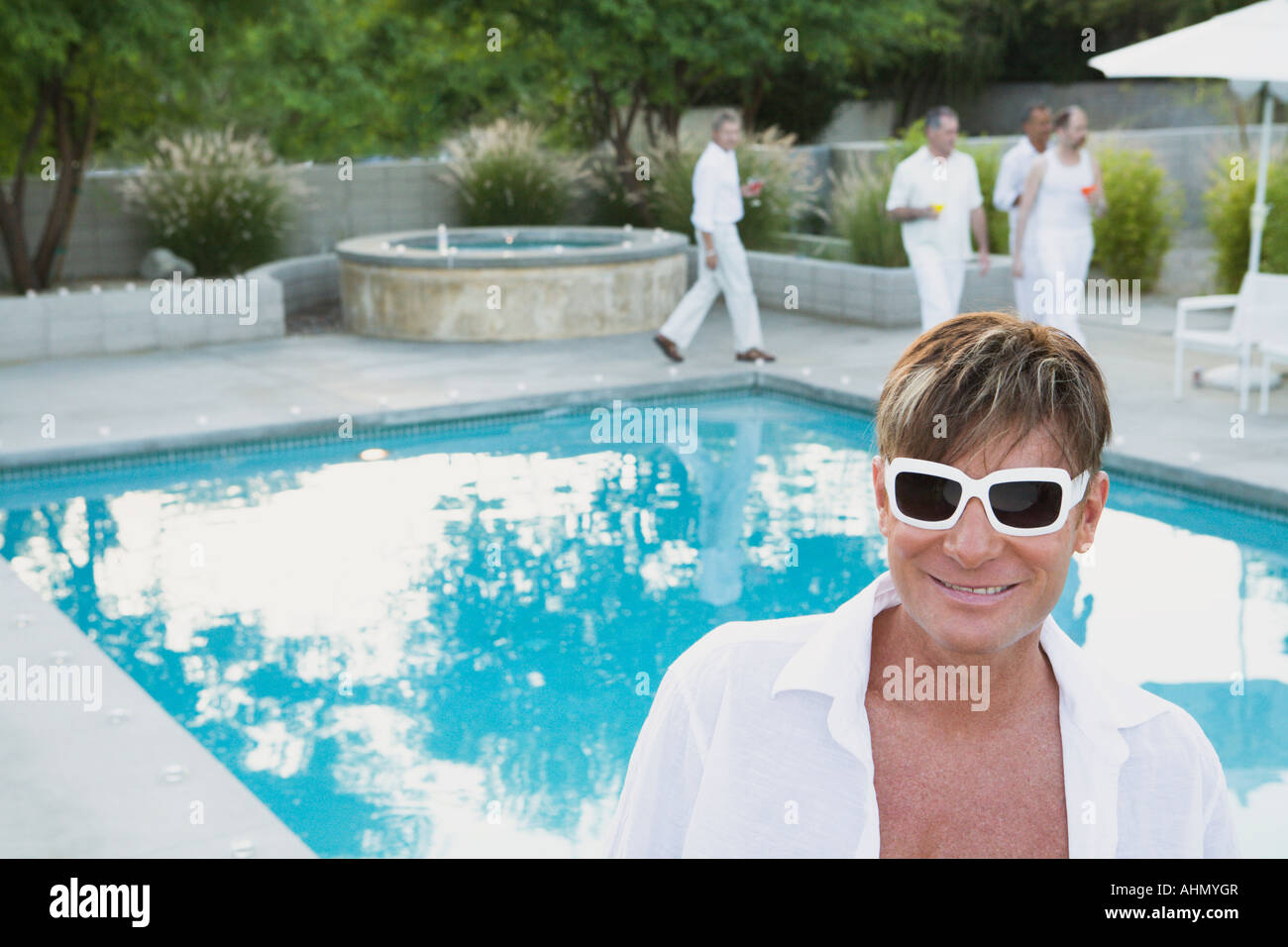 Man standing by swimming pool Stock Photo - Alamy