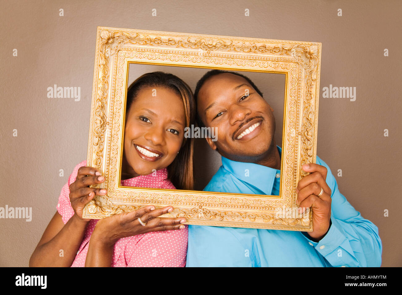 African couple looking through picture frame Stock Photo - Alamy