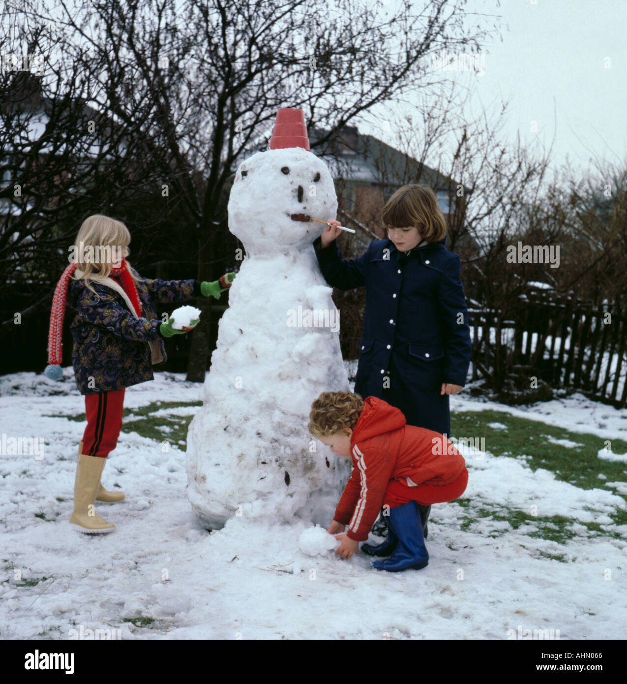 Children making a snowman in a suburban back garden Stock Photo - Alamy