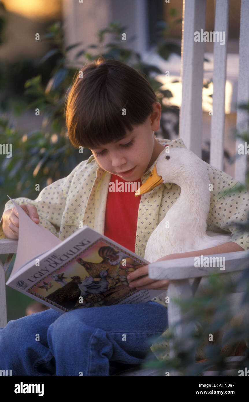 Little boy reading to his pet duck Stock Photo - Alamy