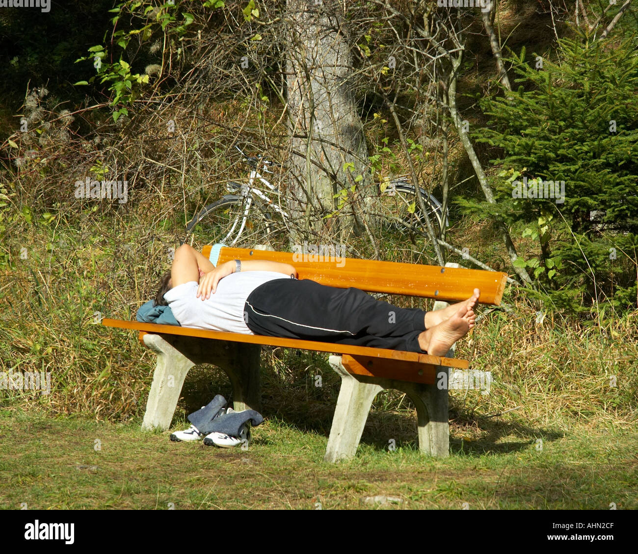 tired woman lying on bench Stock Photo - Alamy