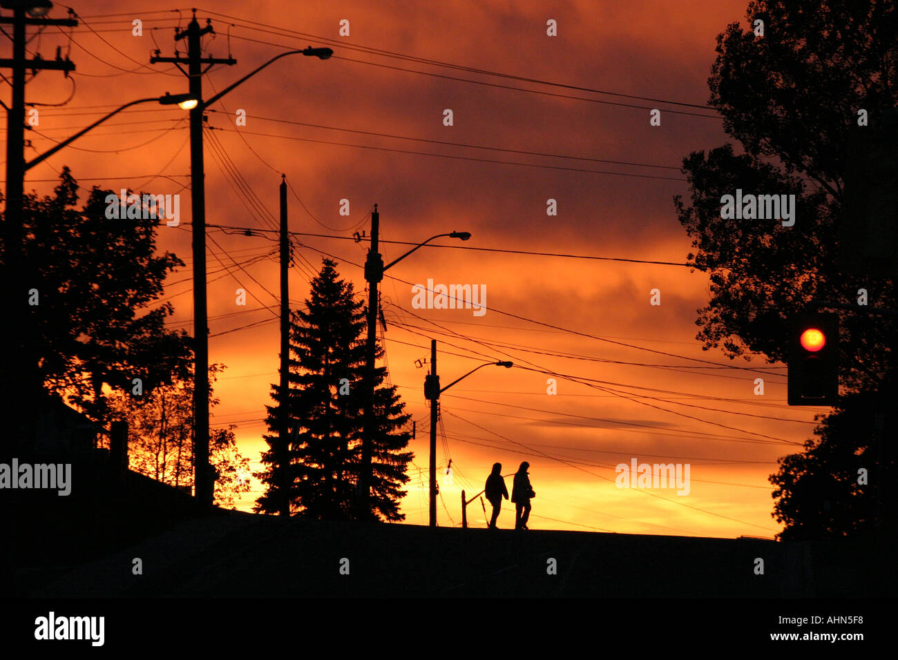 fiery sunset with people in silhouette Stock Photo - Alamy