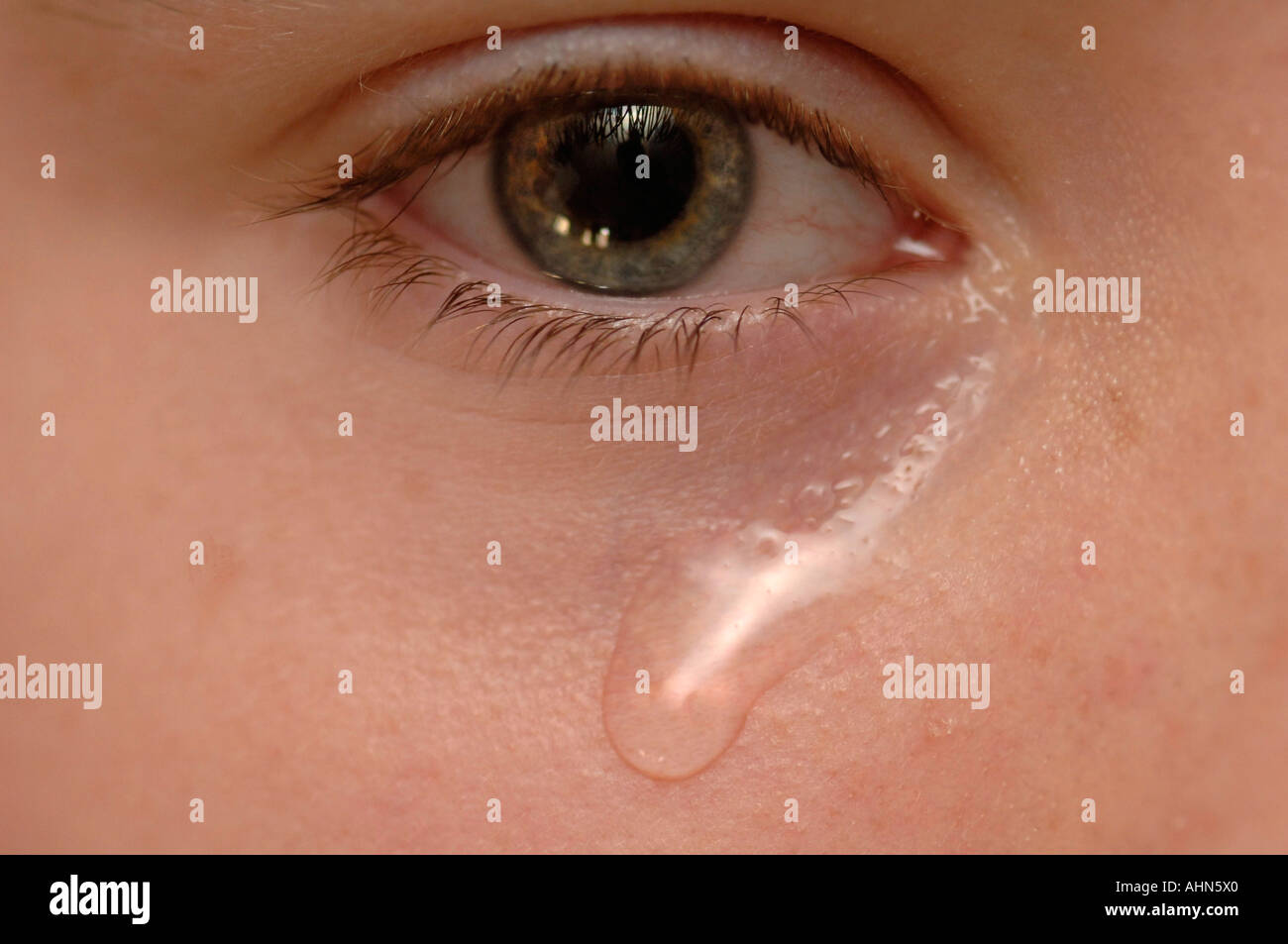 A tear rolls down the cheek of a teenaged girl Stock Photo - Alamy