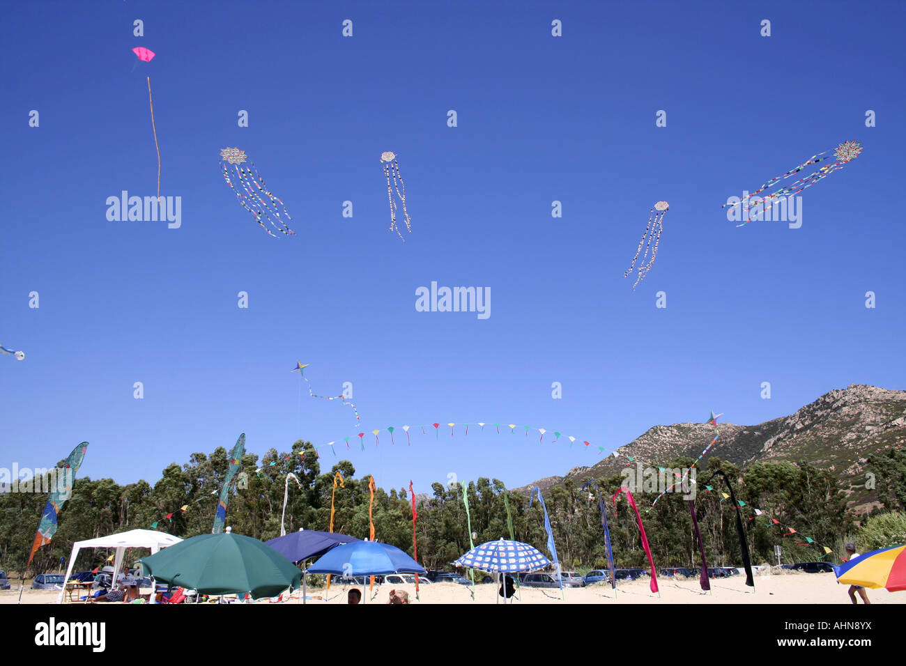 People on beach with colourful kites of Cagliari kite club in ...