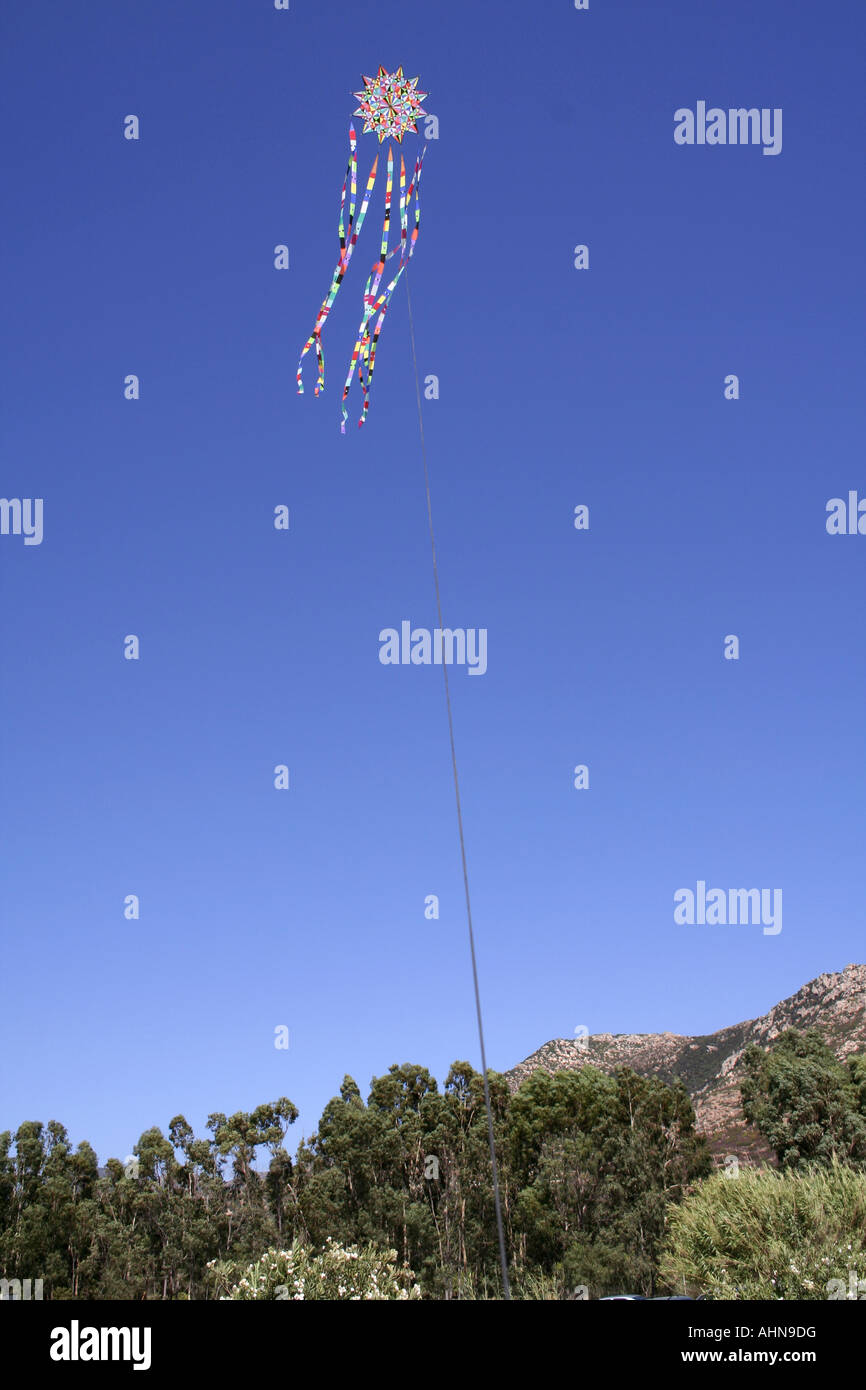 Colourful kite flying in blue summer sky. Taken at Solanas, Sardinia ...