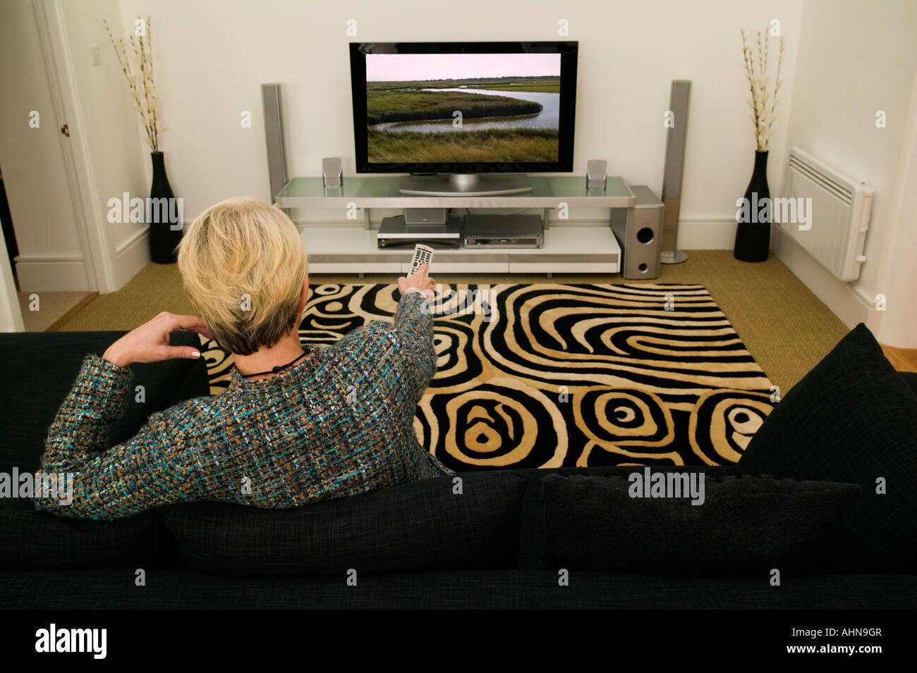 woman changing channel on her television Stock Photo - Alamy