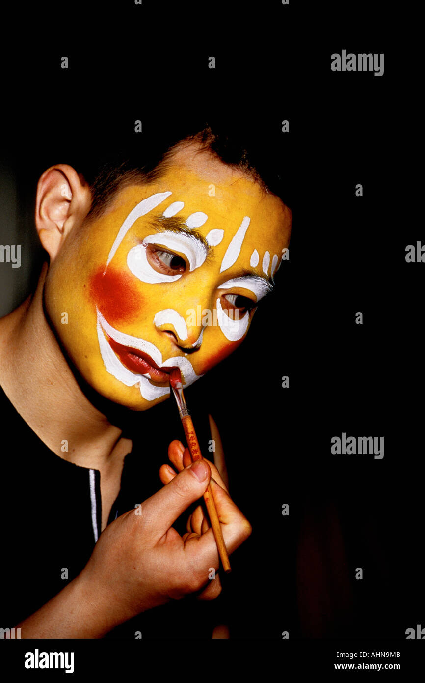 Beijing Opera, wuchou or acrobatic clown character applying greasepaint ...