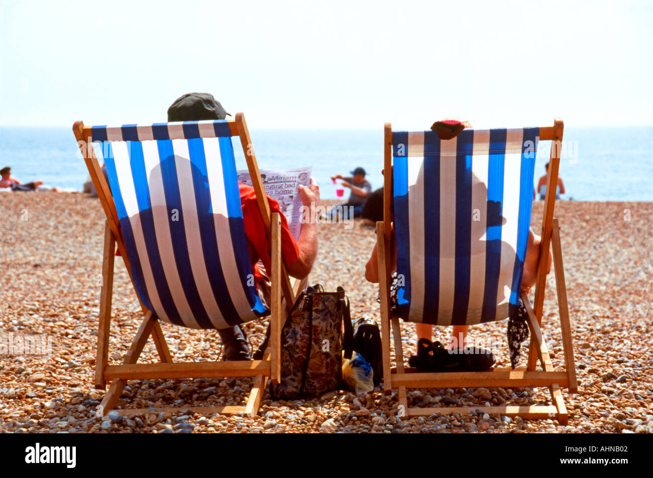 Enjoying the view from deck chairs on a Summers day on Brighton beach ...
