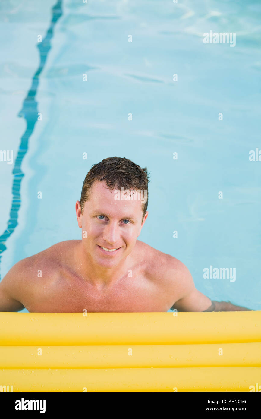 Man holding a raft in swimming pool Stock Photo - Alamy