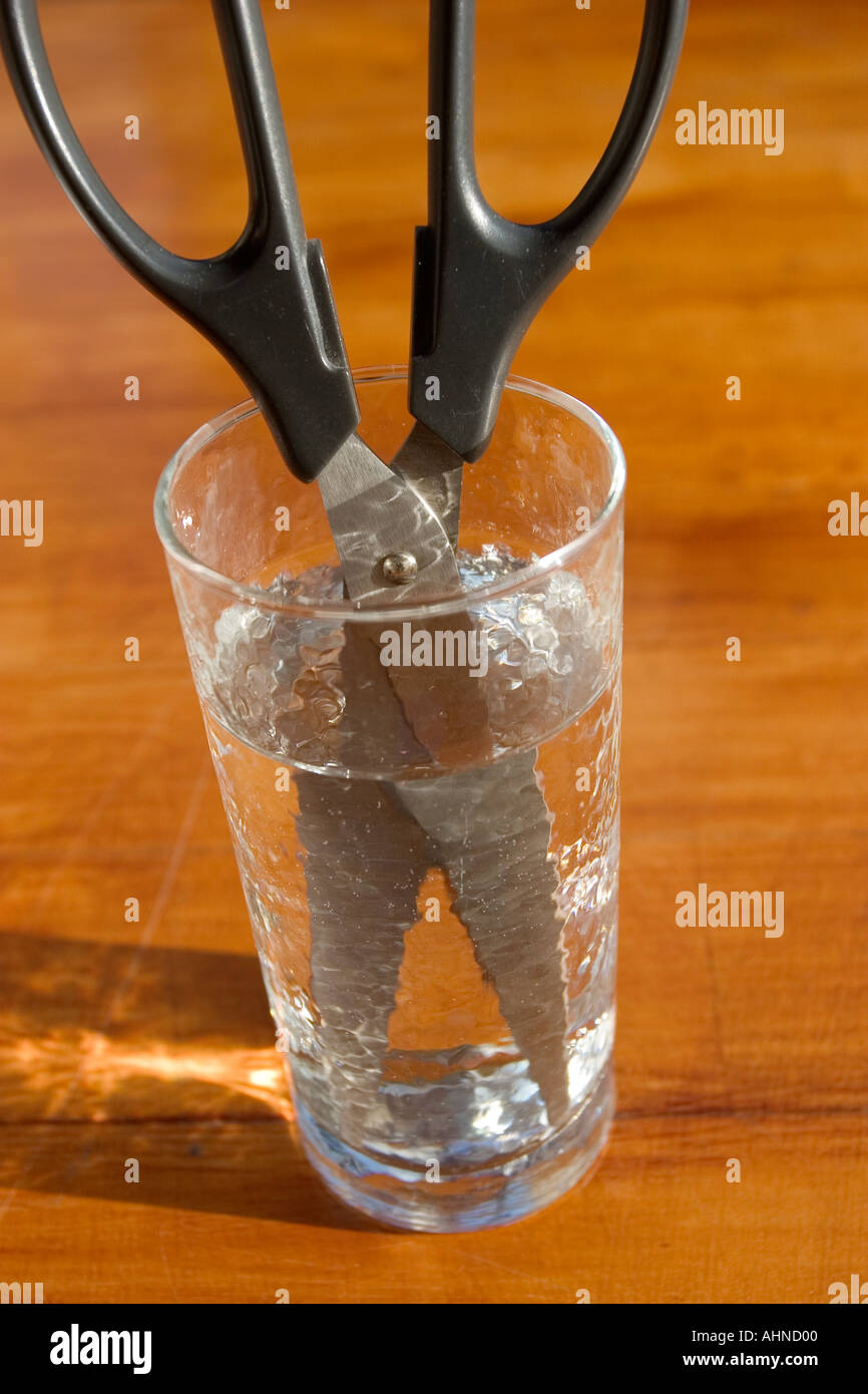 scissor in a full water glass Stock Photo - Alamy