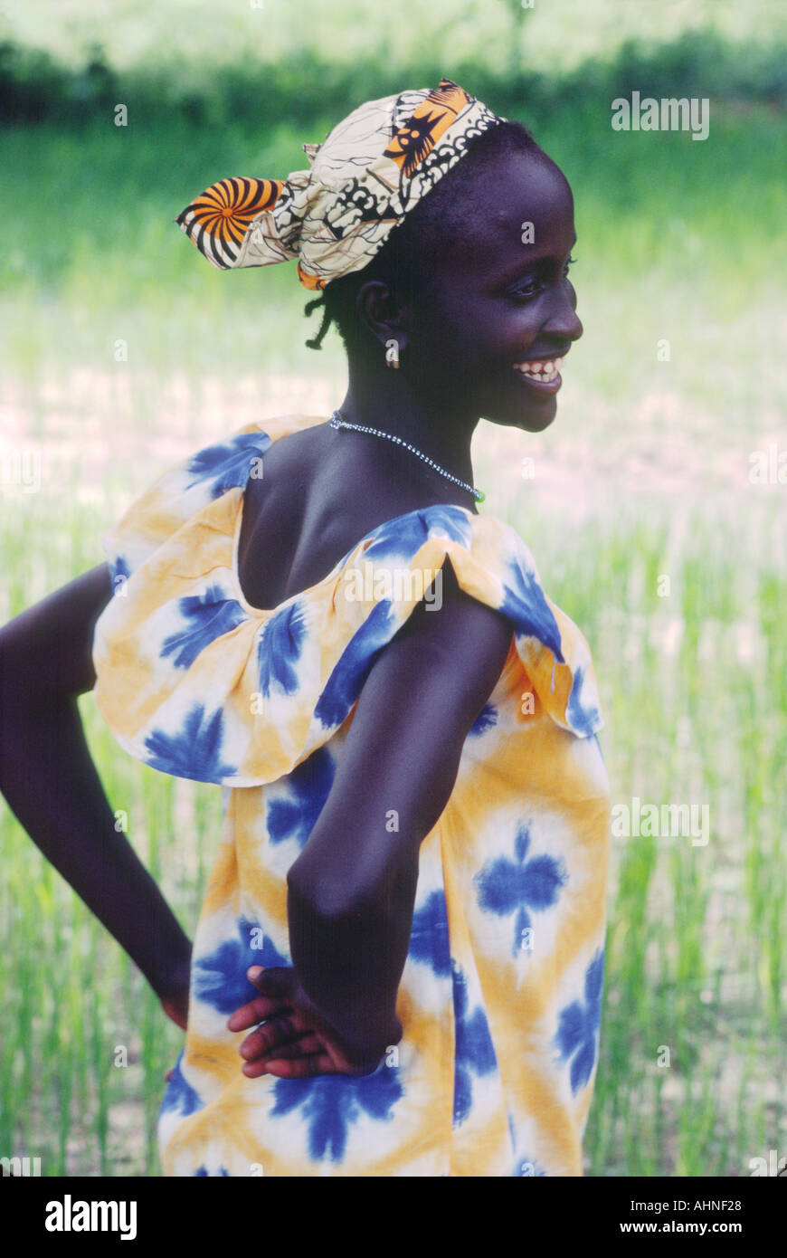 The Gambia, West Africa. Mandinka woman in traditional batik dress in ...