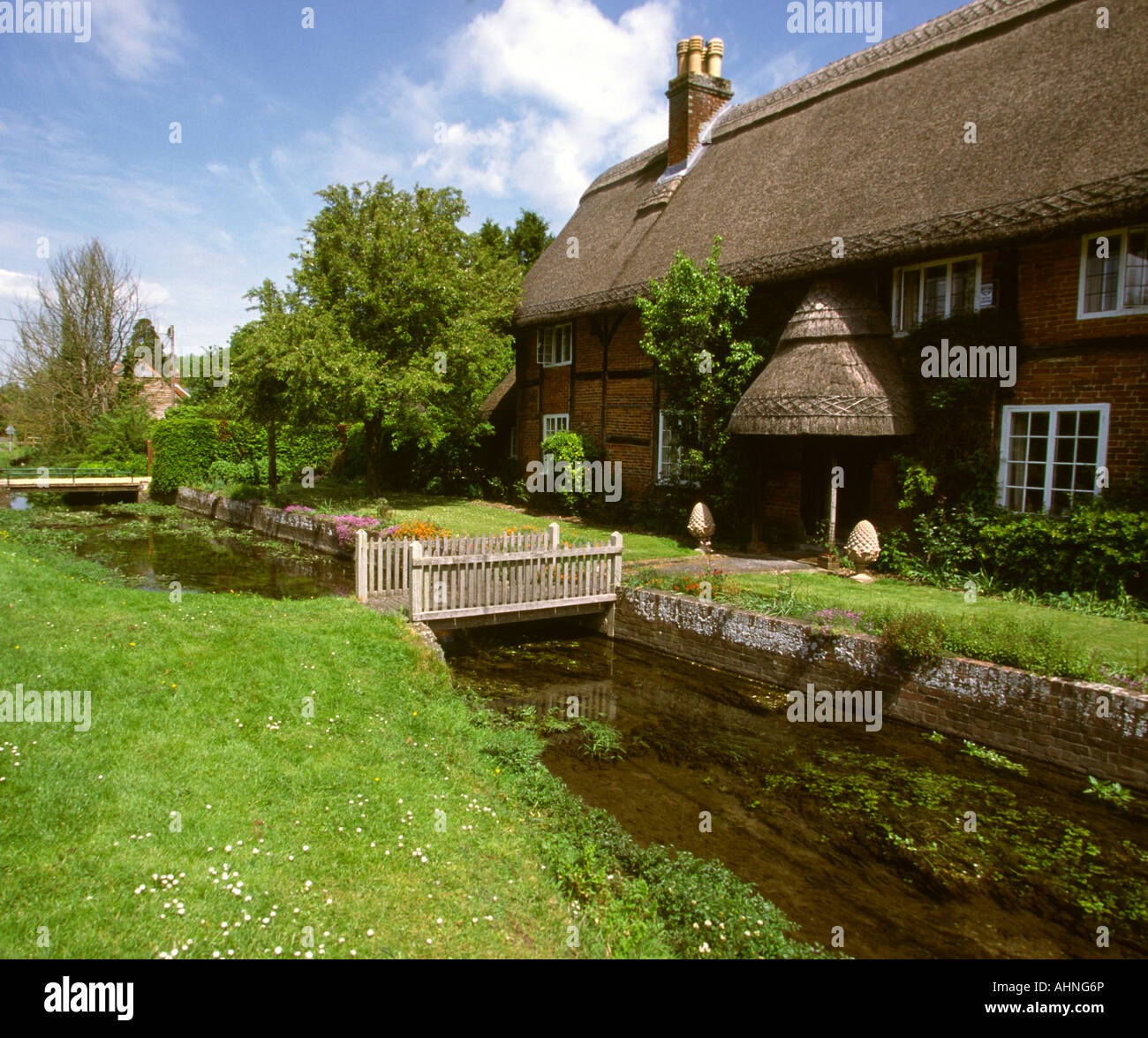 UK Hampshire Rockbourne thatched cottage beside village stream Stock ...