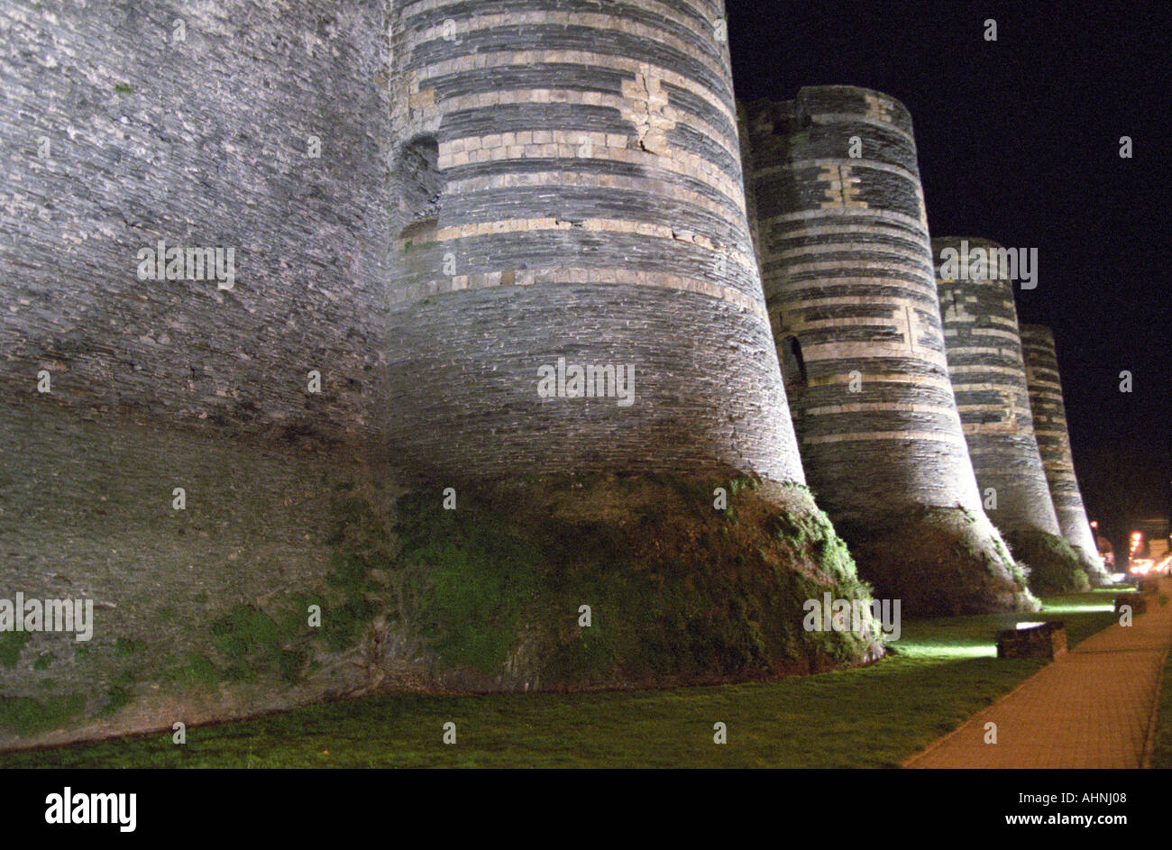 The imposing Chateau d'Angers castle at night. Built with black and ...