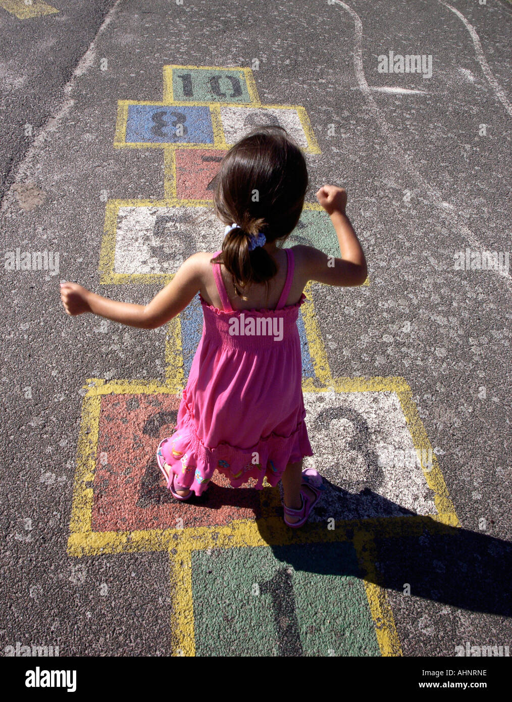 child plays hop-scotch alone in the park Stock Photo - Alamy