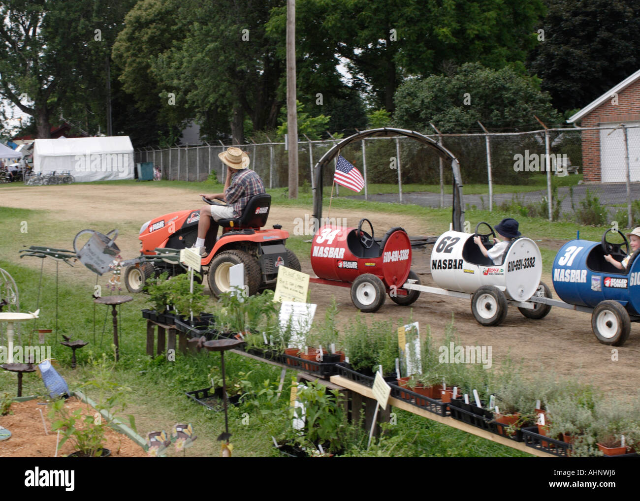 Tractor pulls small cars - improvised kiddie ride Stock Photo - Alamy