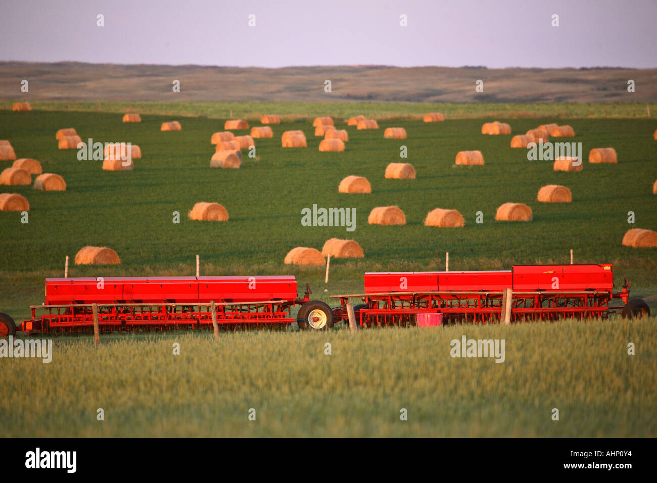 seeding equipment near field with hay bales Stock Photo - Alamy