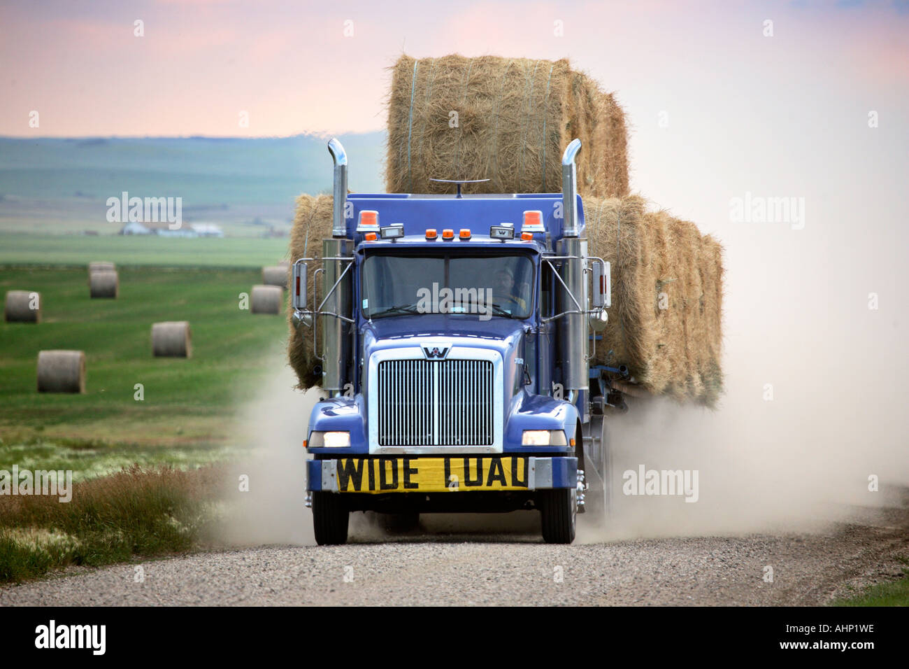 Truck hauling hay bales on a country road in scenic Saskatchewan Canada ...