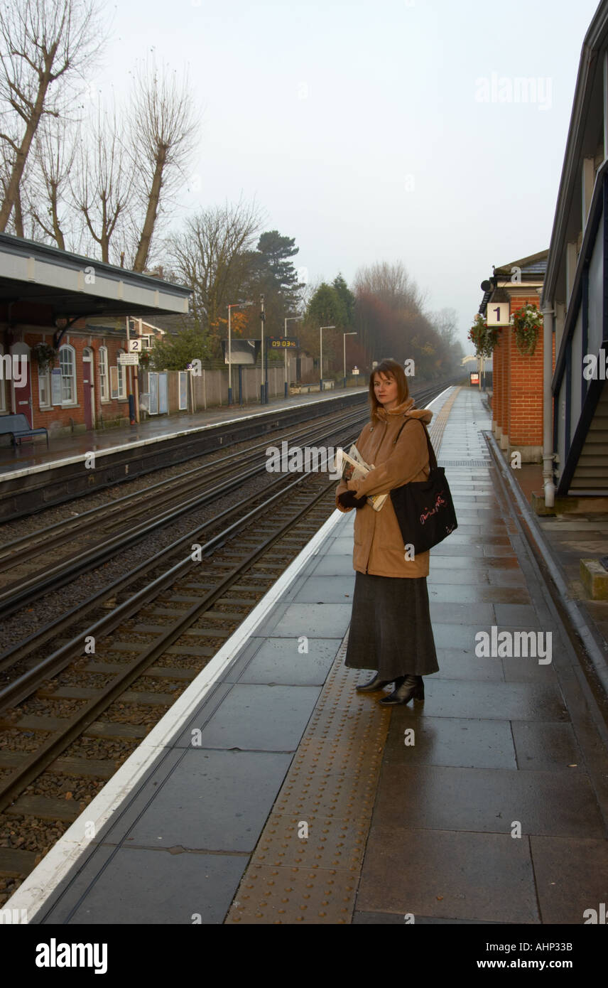 Woman holding newspaper standing on platform waiting for train Stock ...