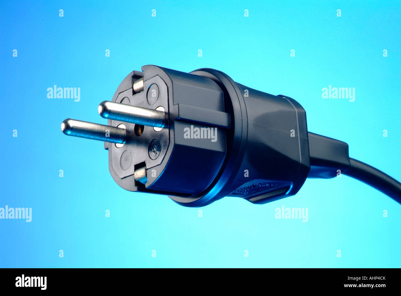 Black plug on blue background Stock Photo - Alamy