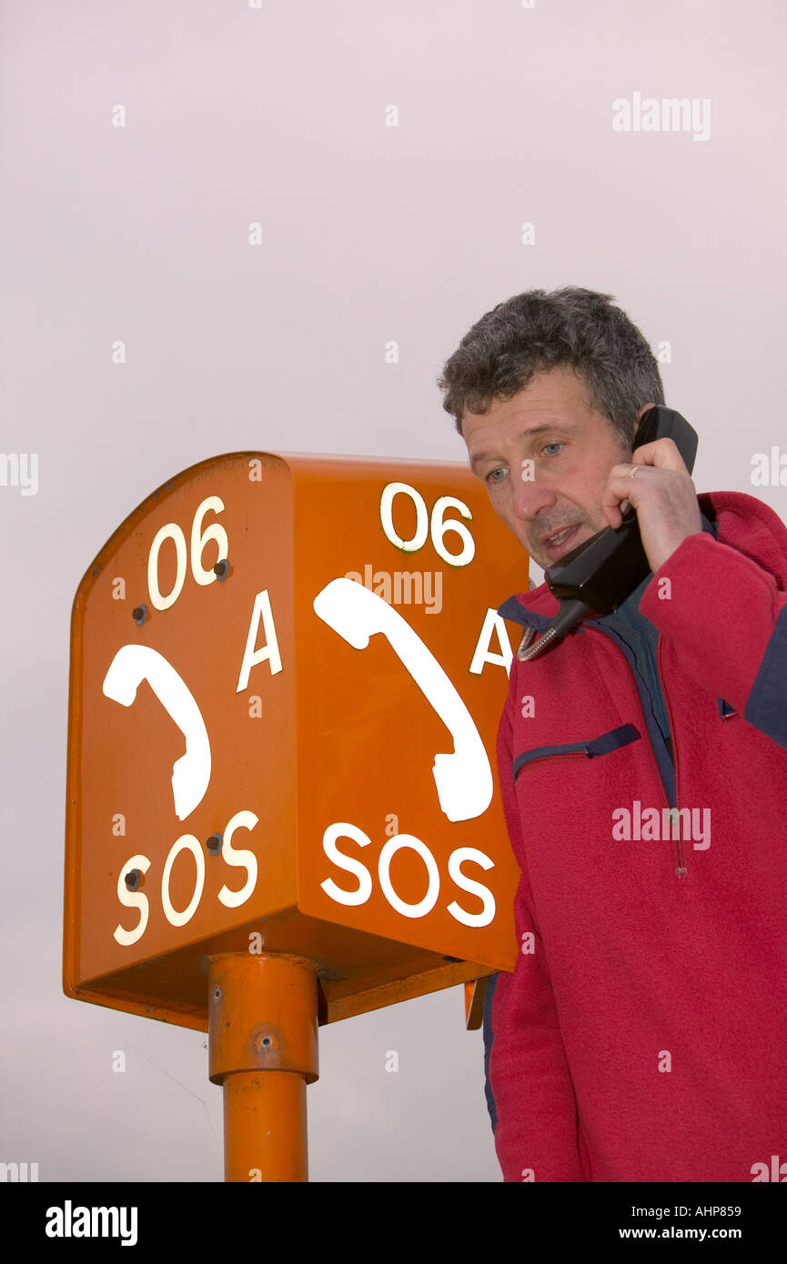 a stranded motorist using an SOS phone Stock Photo - Alamy
