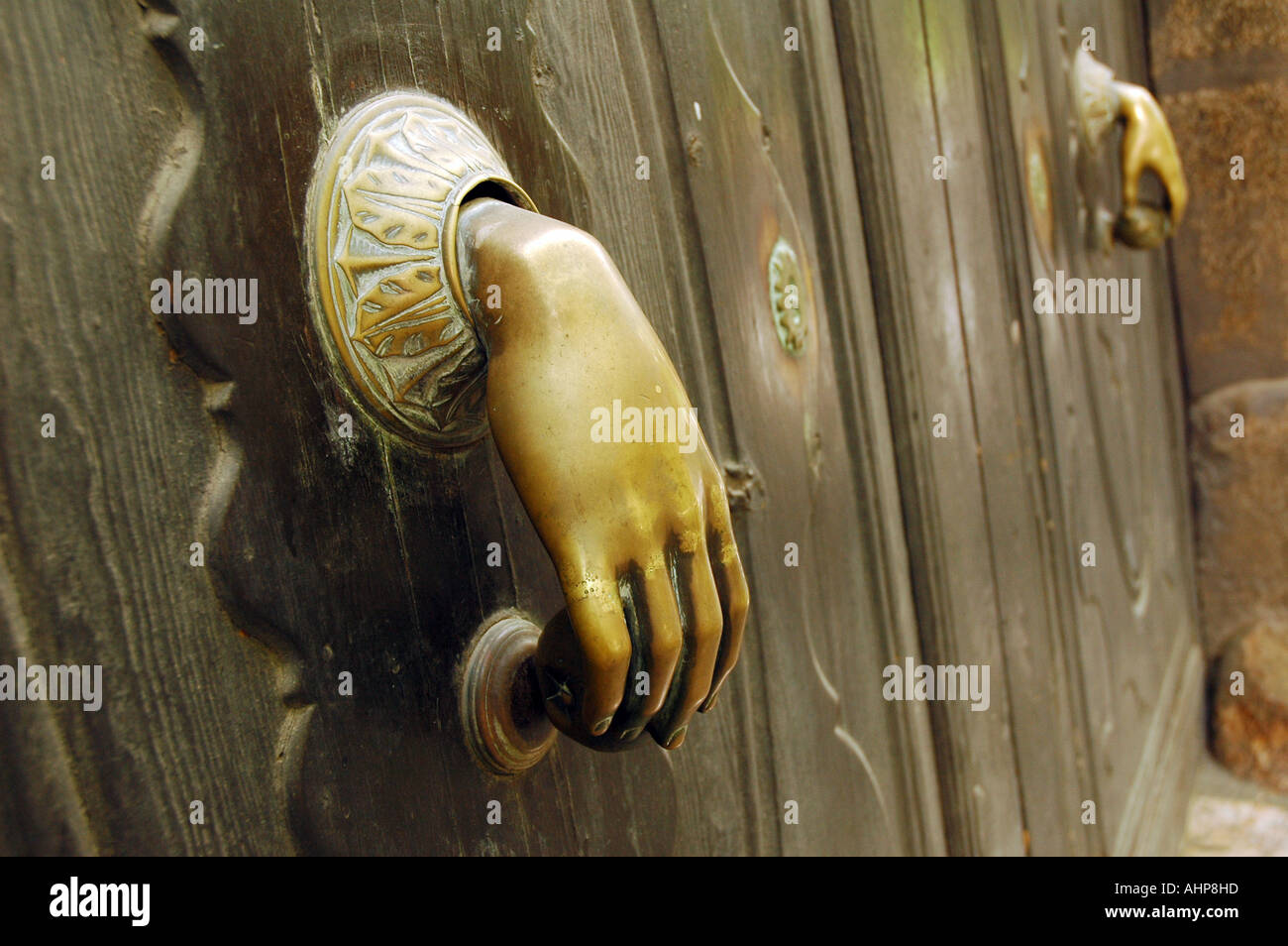 Door handles of ornate brass in the shape of a human hand on the door ...