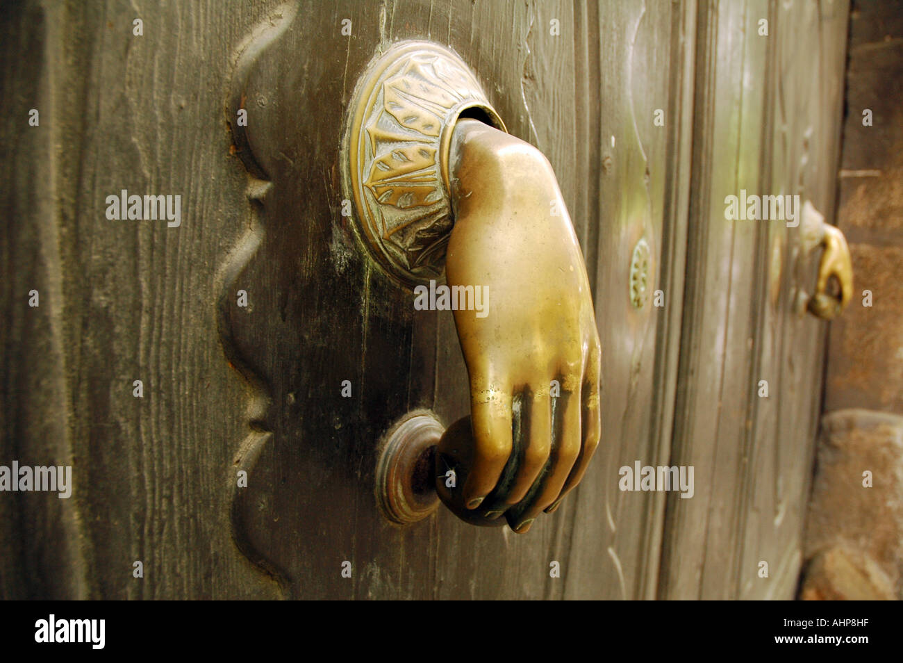 Door handles of ornate brass in the shape of a human hand on the door ...