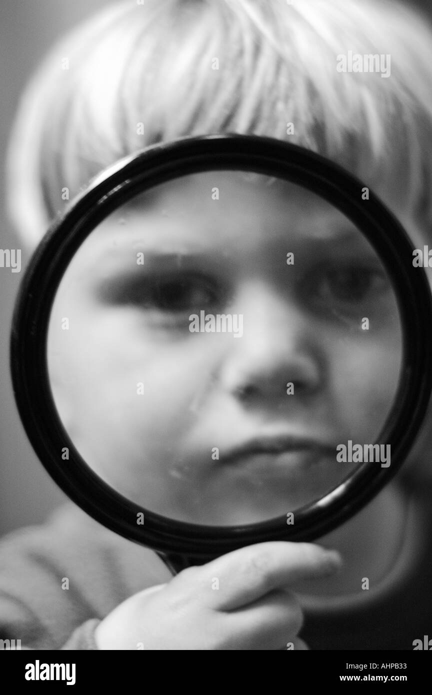Child exploring using holding magnifying glass Stock Photo - Alamy