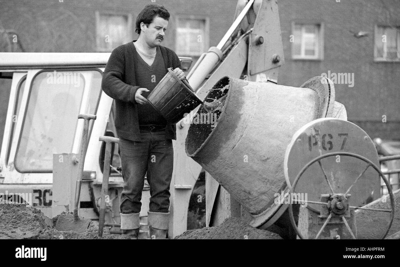 Man mixing cement with mechanical revolving mixer Stock Photo - Alamy