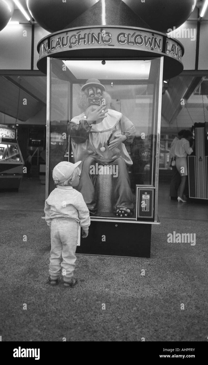 Boy looking at mechanical clown in seaside entertainment machine Stock ...
