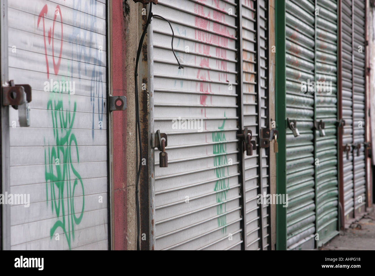 Closed locked and shuttered shops in an area awaiting regeneration ...