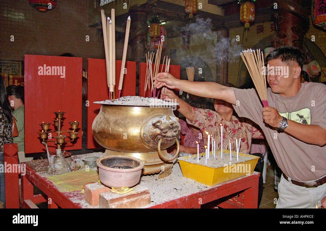 Man putting jostick at a Chinese temple in Kuala Lumpur Malaysia during ...