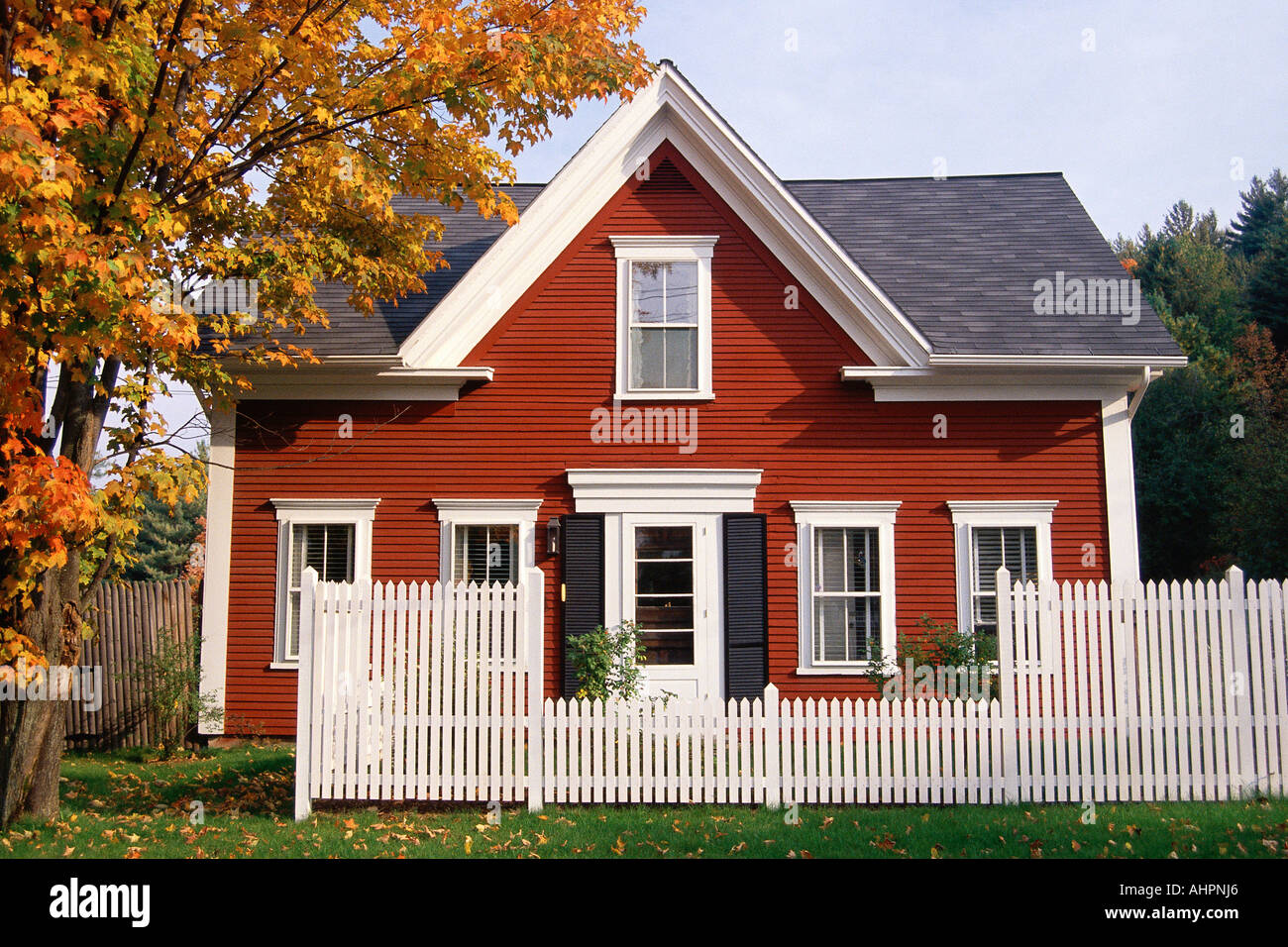 Red wooden house with white picket fence in autumn New England Stock ...