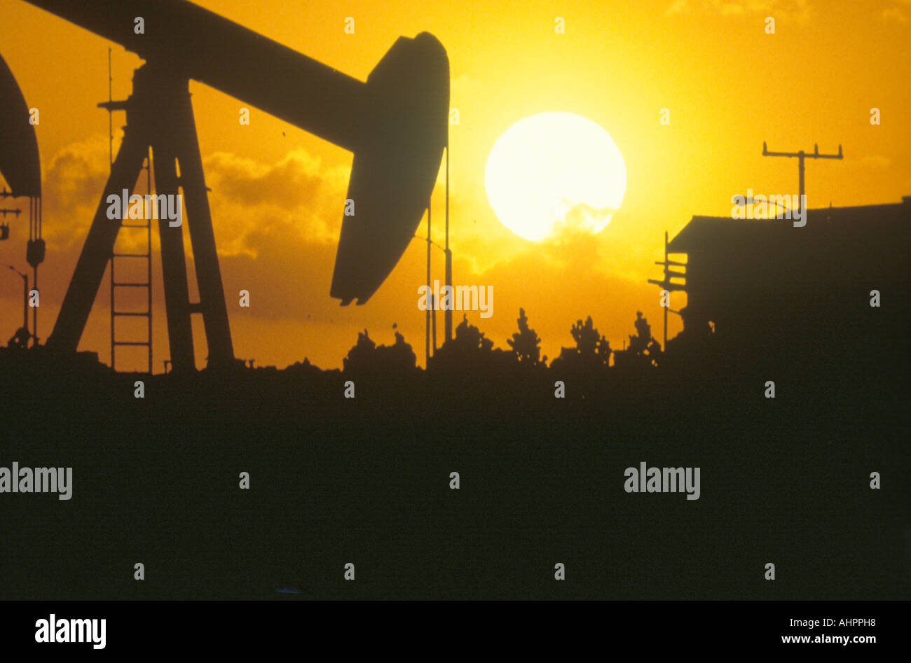 Oil drilling well silhouetted at sunset Stock Photo - Alamy