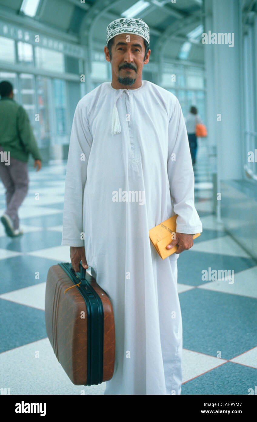 Middle Eastern man wearing white robes holding suitcase JFK Airport New ...