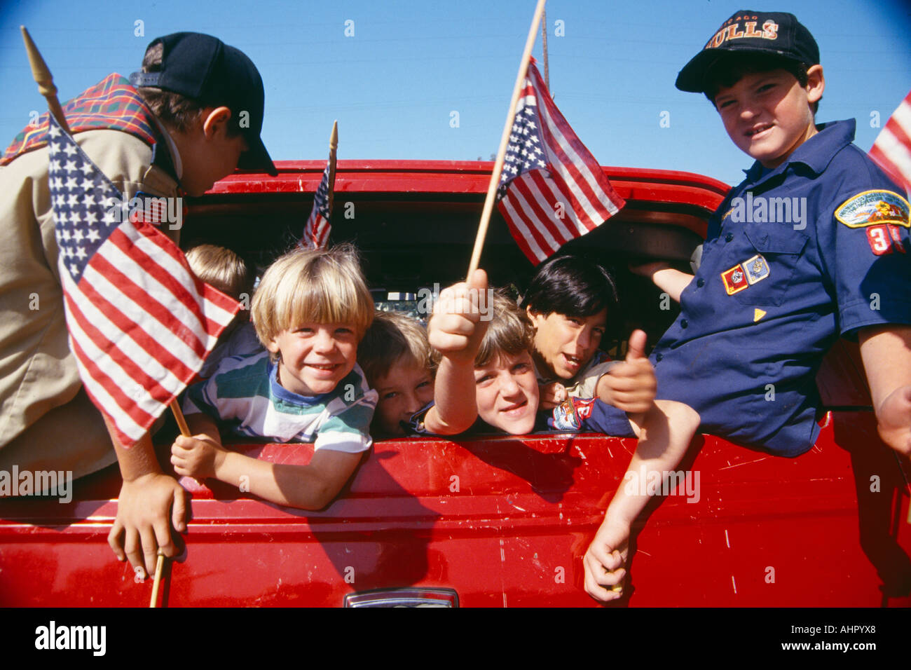 Cub Scouts waving American flags from back of car Los Angeles ...