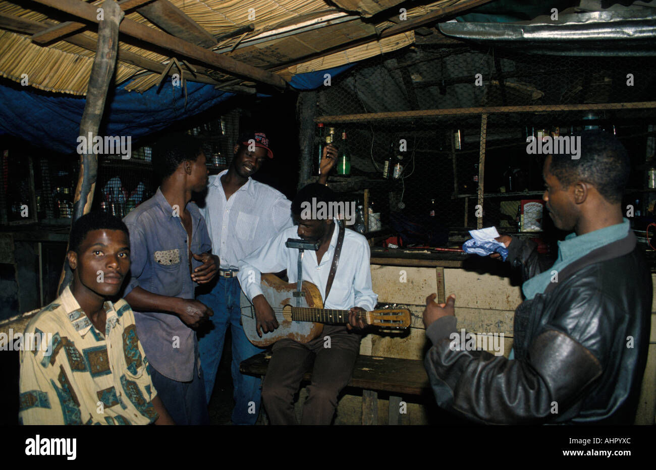 people enjoying a night out at a small bar in Barracas de Museu, Maputo ...
