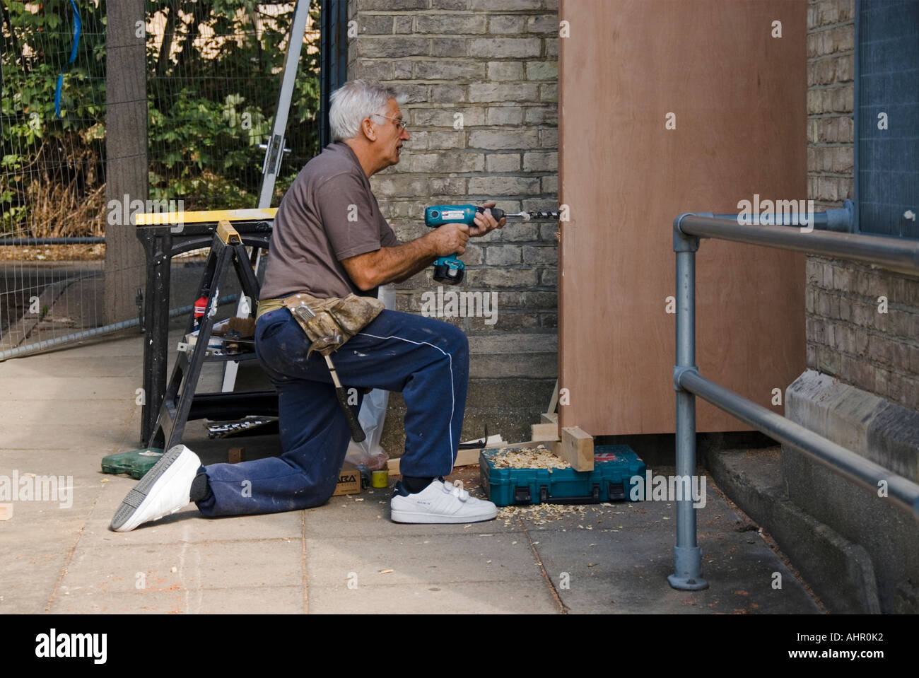 Workman fitting a lock and handle to a wooden door Stock Photo - Alamy