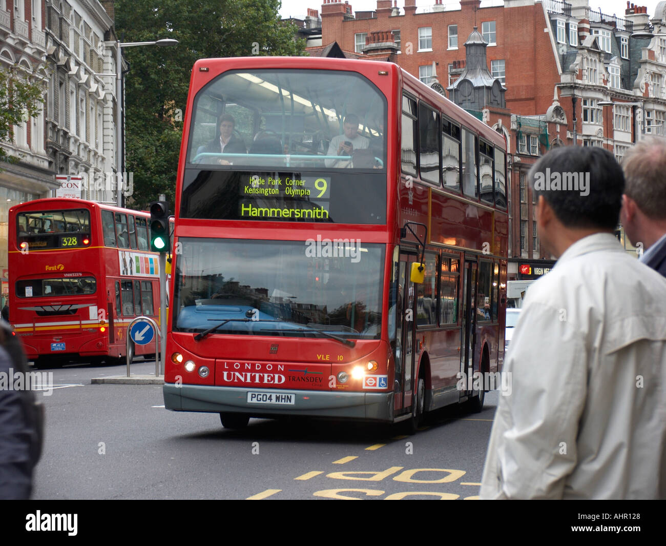 Men waiting for bus Kensington High Street London England UK Stock ...