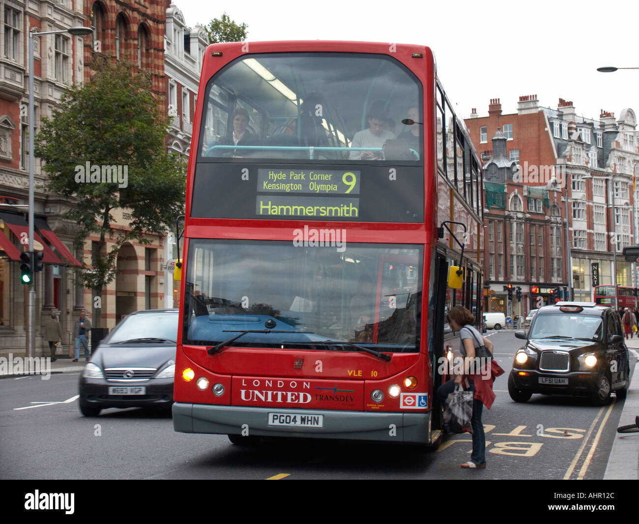 Woman getting on bus Kensington High Street London England UK Stock ...