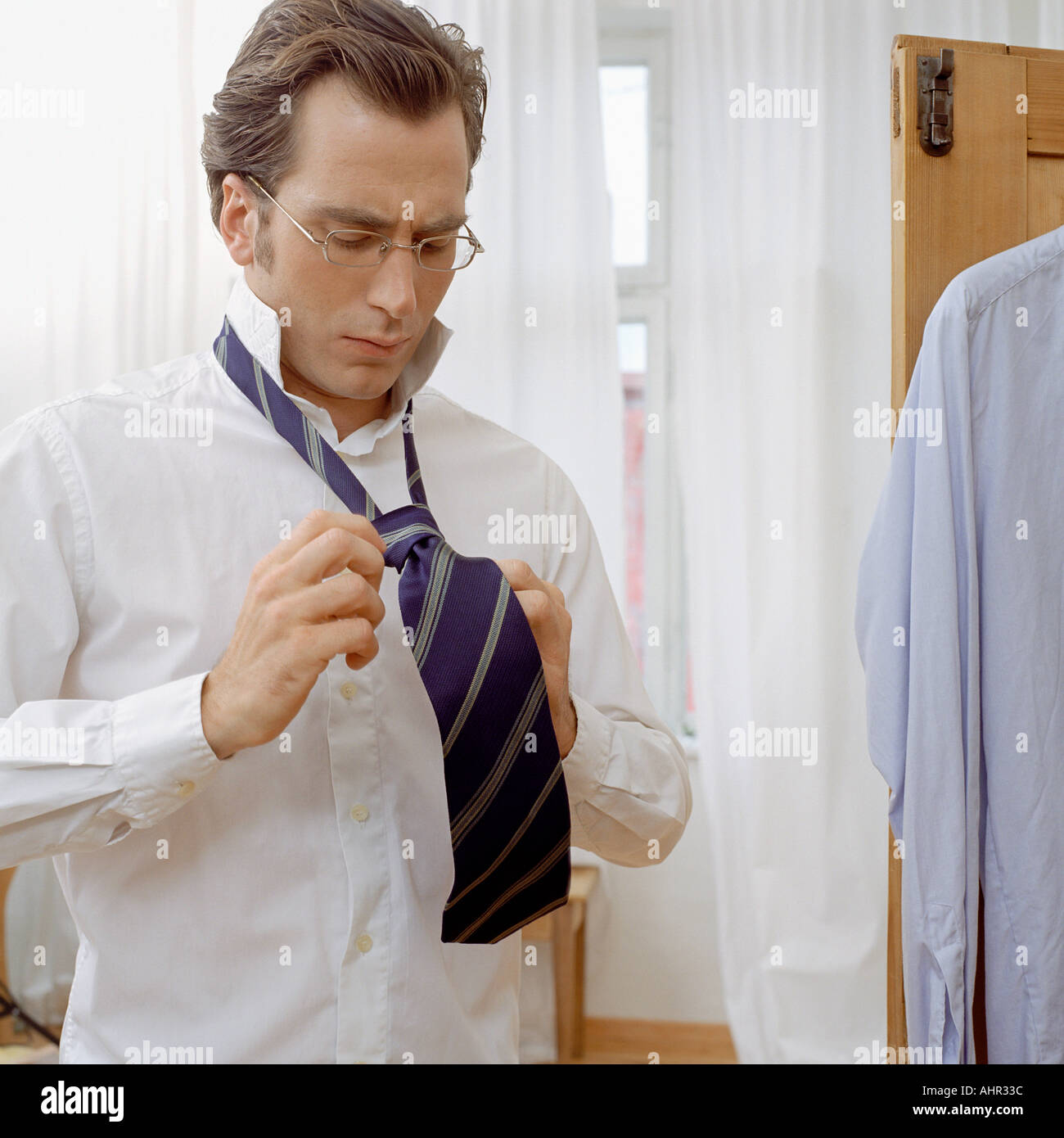 Man getting dressed wears tie Stock Photo - Alamy