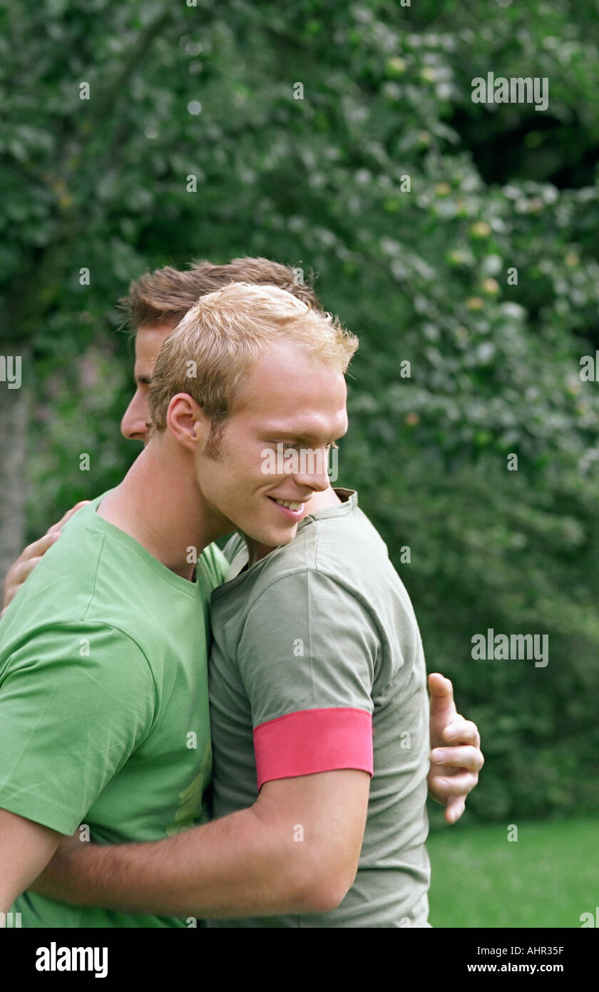 Two male friends embracing Stock Photo - Alamy