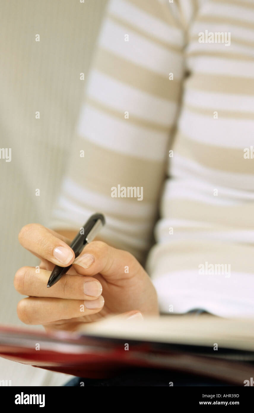Woman using pen and paper Stock Photo - Alamy