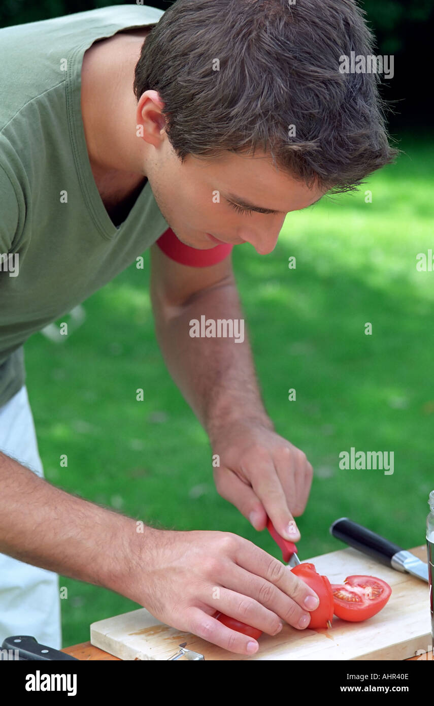 Young male chopping tomatoes Stock Photo - Alamy