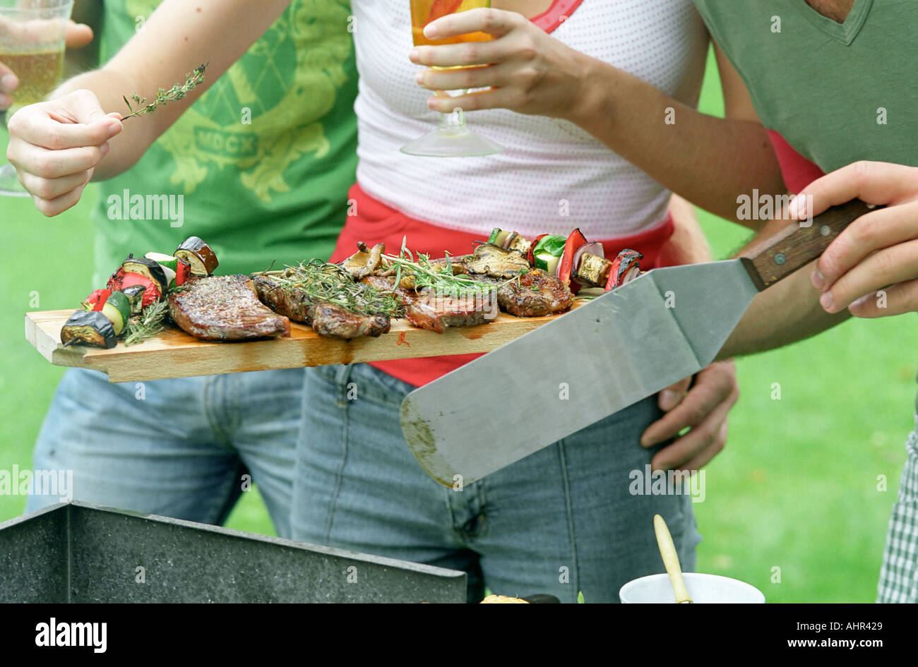 Young people having a barbeque Stock Photo - Alamy