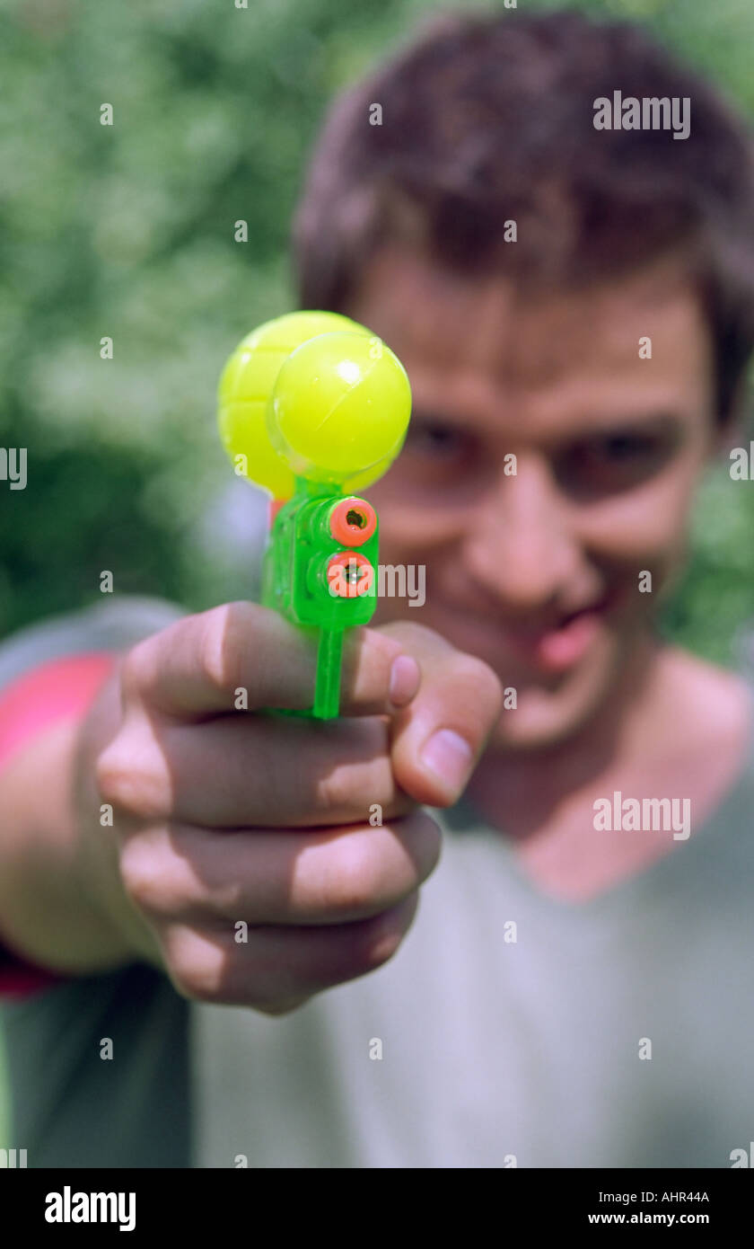 Young man aiming water pistol Stock Photo - Alamy